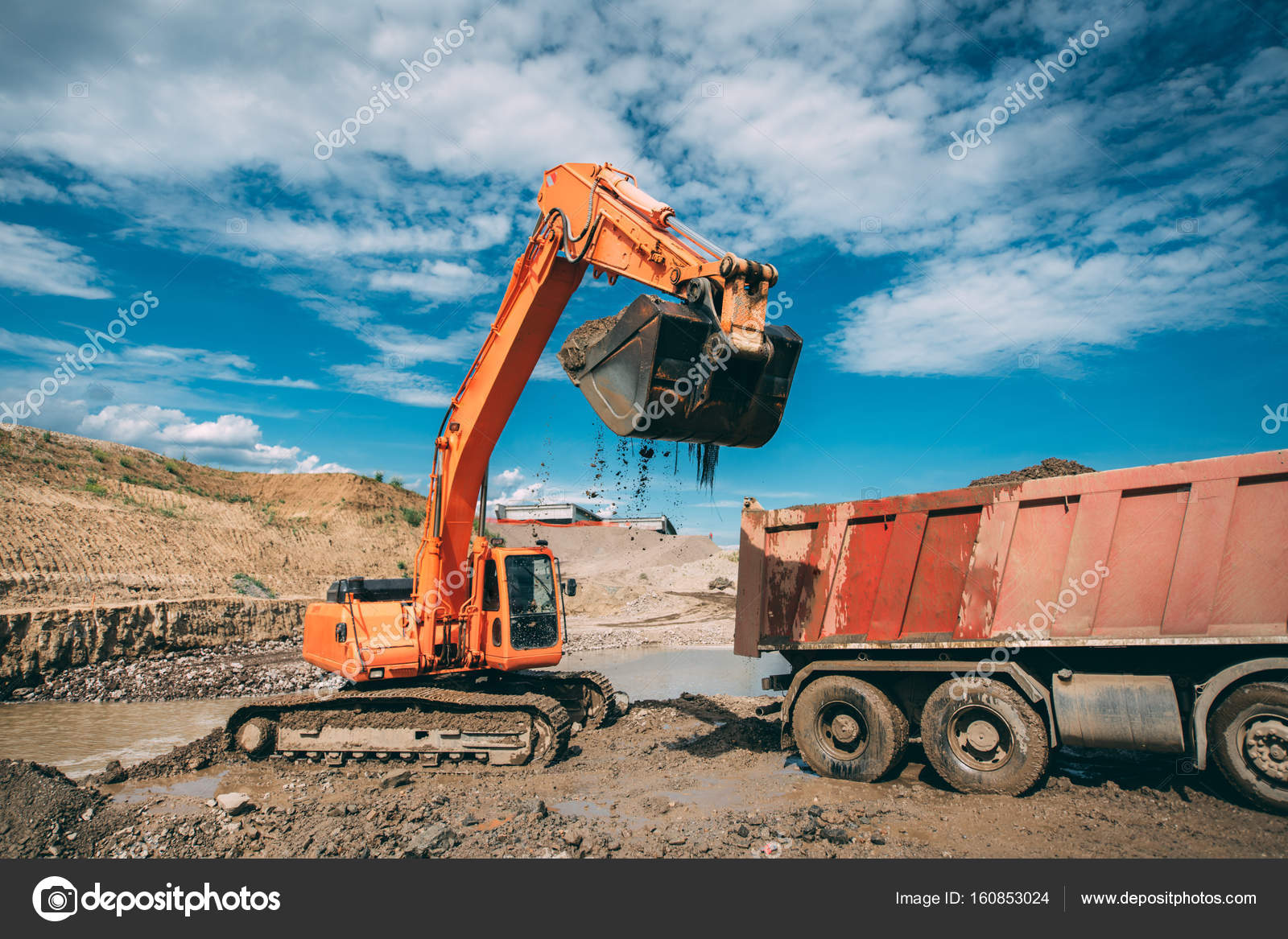 Excavator, bulldozer loading dumper truck during highway construction ...