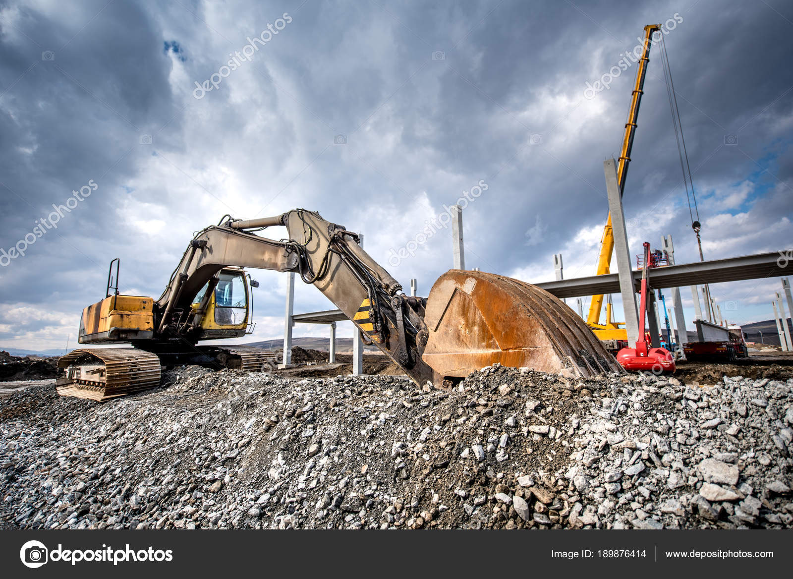 Heavy duty industrial excavator loading gravel on construction site ...