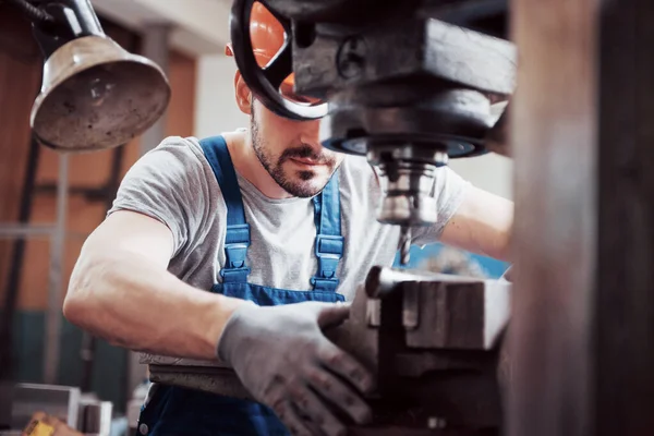 Portrait of a young worker in a hard hat at a large metalworking plant ...