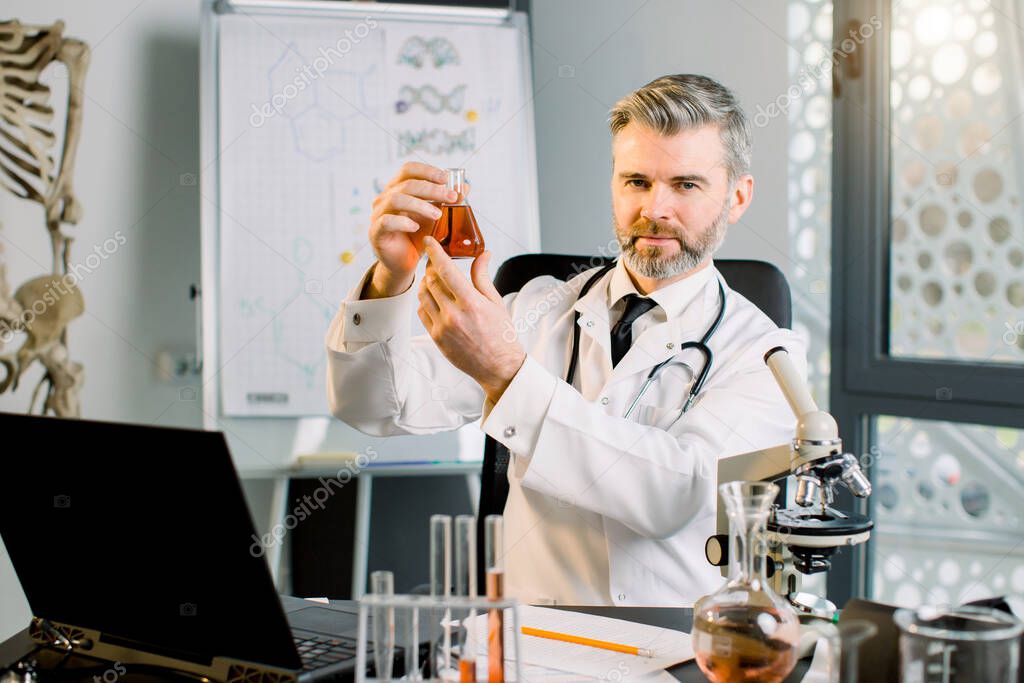 Sonriente hombre maduro caucásico científico o médico probando nuevos ...