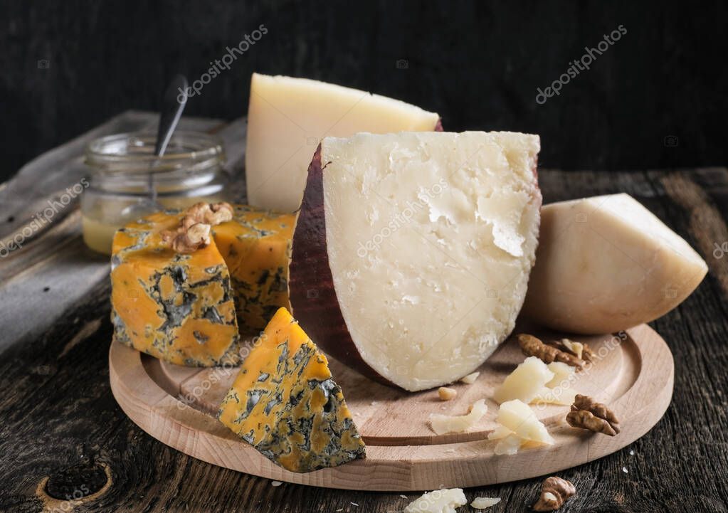 Trozos de Jugas y queso Shropshire Blue con uvas en un plato de madera ...