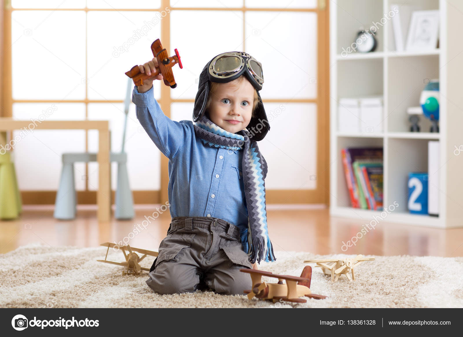 Child pretending to be aviator. Kid playing with toy airplanes at home ...