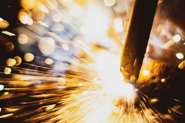 welder doing metal work at night, front and background blurred with ...