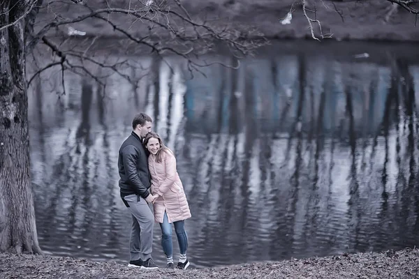 couple in love in spring park, trees without leaves early spring or ...