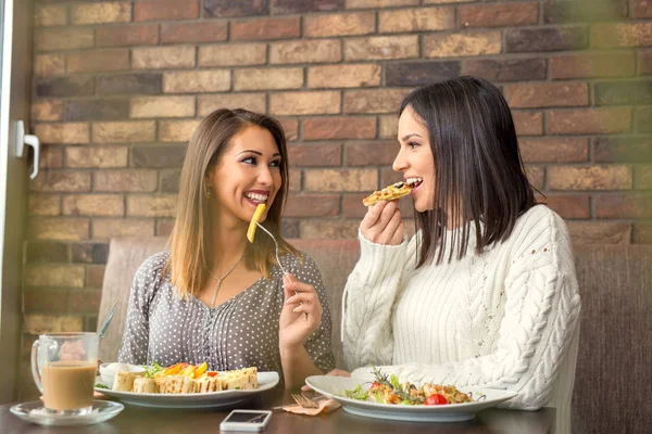 Two girlfriends having lunch together at a restaurant Stock Photo by ...