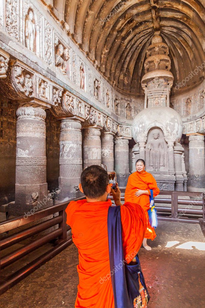AJANTA, INDIA - 6 DE FEBRERO DE 2017: Monjes budistas tomando fotos en el chaitya (sala de ...