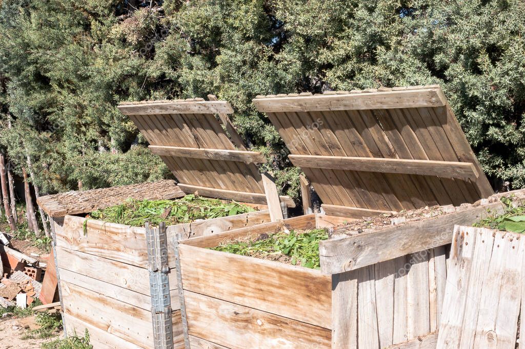Par de compostadores de madera hechos a mano llenos de residuos ...