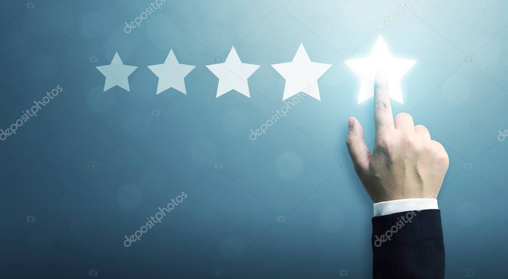 Mano de hombre de negocios tocando el símbolo de cinco estrellas para aumentar la calificación ...