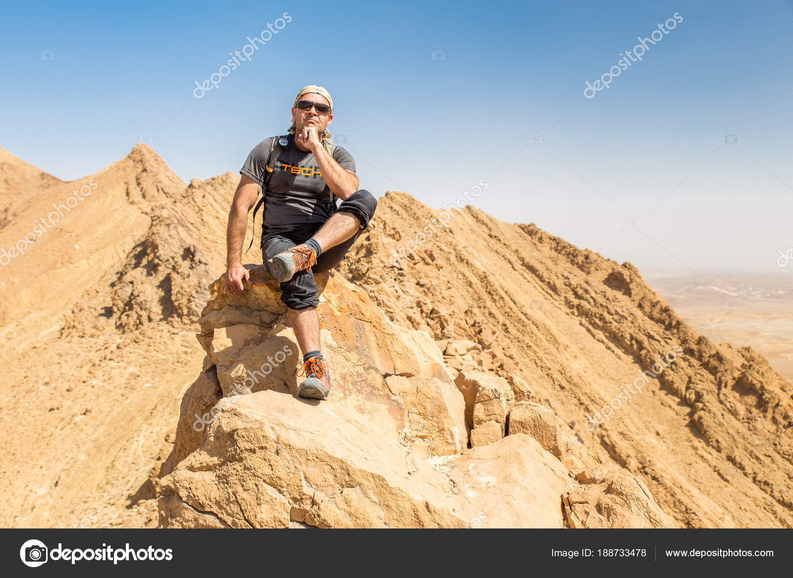 Backpacker tourist sitting desert mountain cliff ridge edge landscape ...