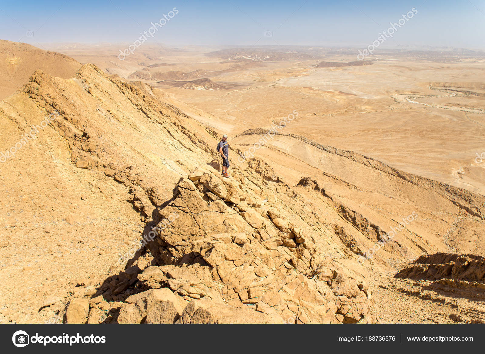 Backpacker tourist standing desert mountain cliff ridge edge lan ...
