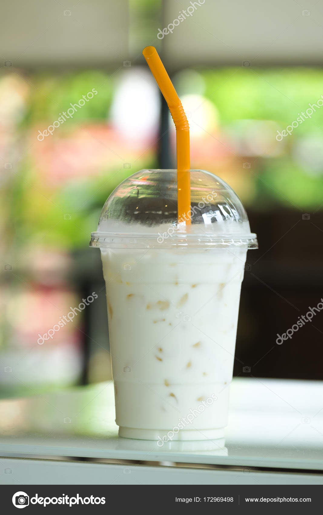 Ice Milk in Plastic cup on the cafe table. — Stock Photo © thaiprayboy ...