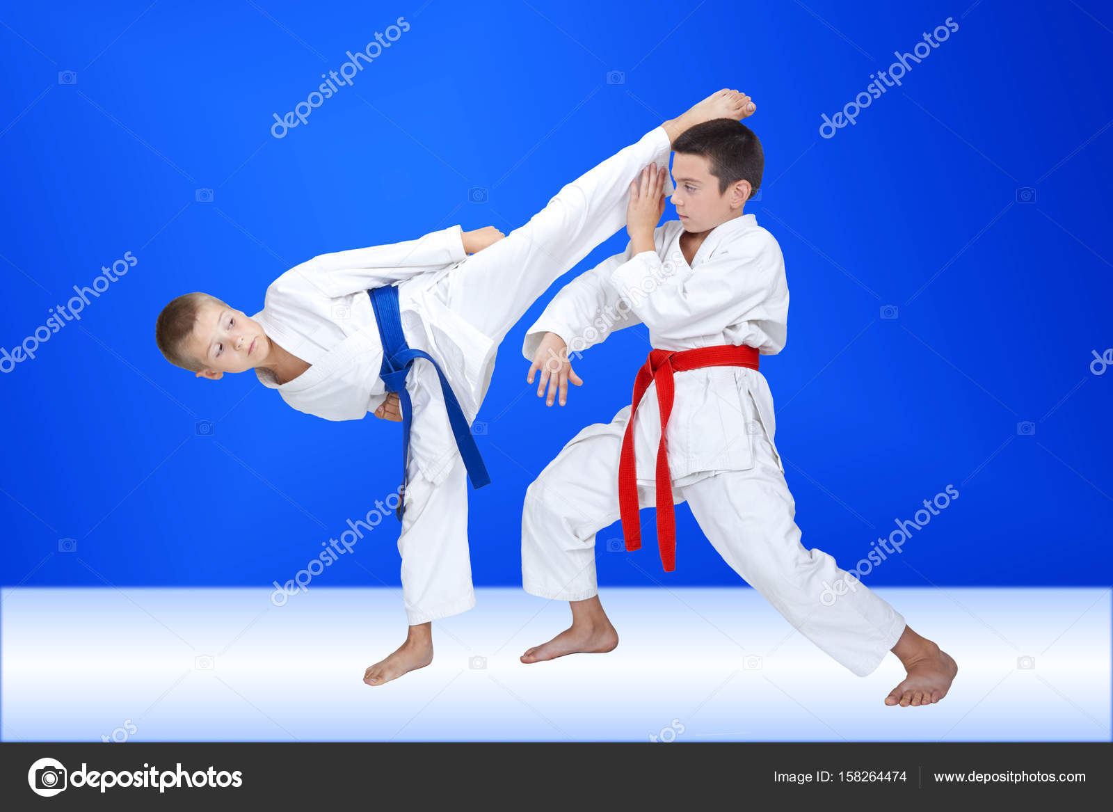 Boys in karategi are training a circular kick and block — Stock Photo ...