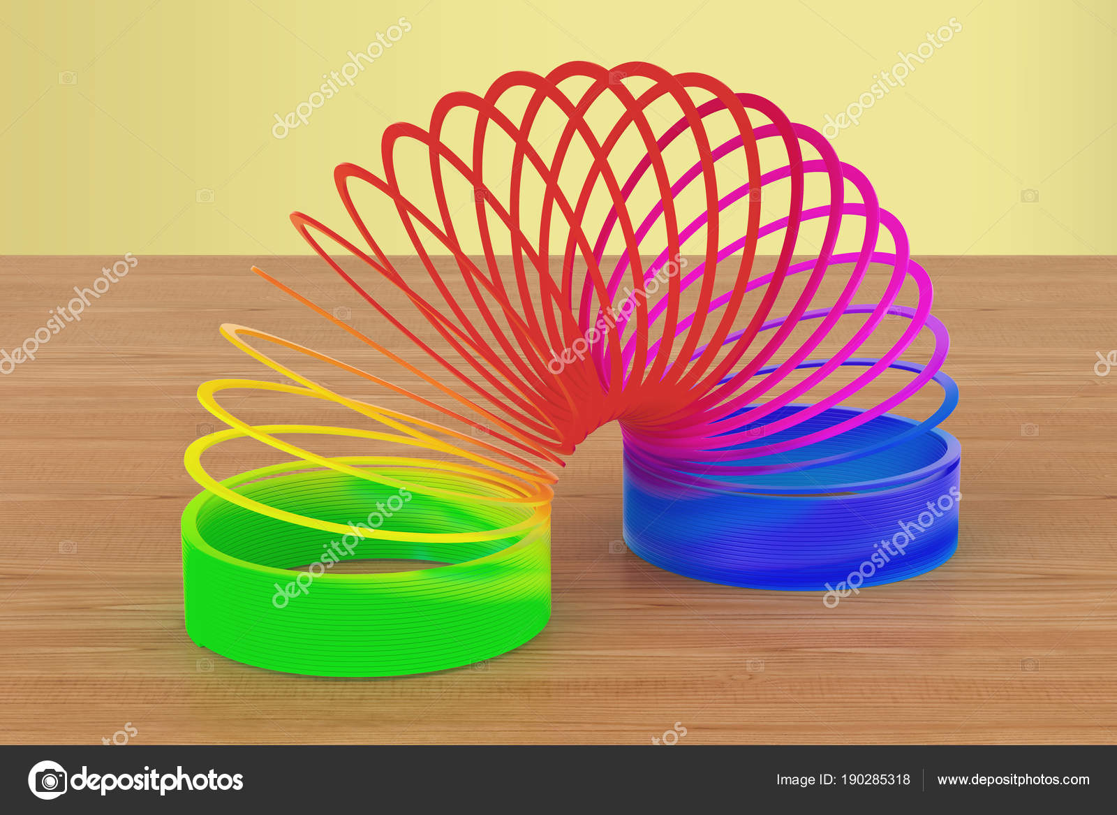 Rainbow colored plastic, slinky toy on the wooden table. 3D rend Stock ...