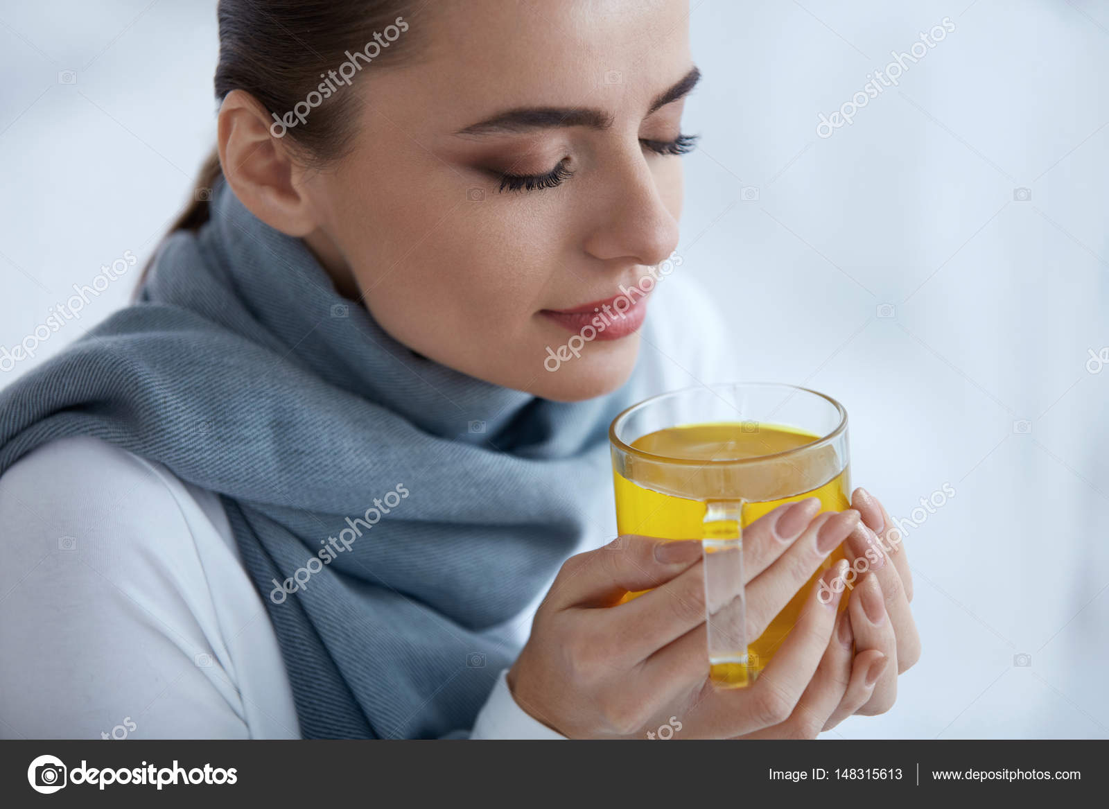 Hermosa mujer bebiendo y oliendo caliente caliente amarillo bebida ...