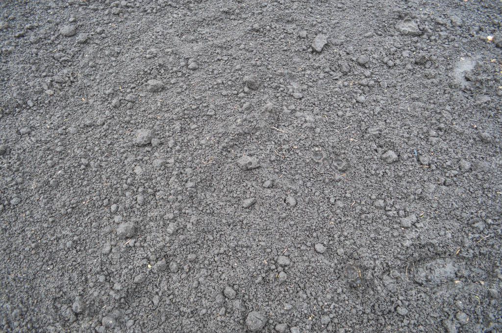 Una vista de la tierra húmeda natural agrietada negra oscura y fértil ...