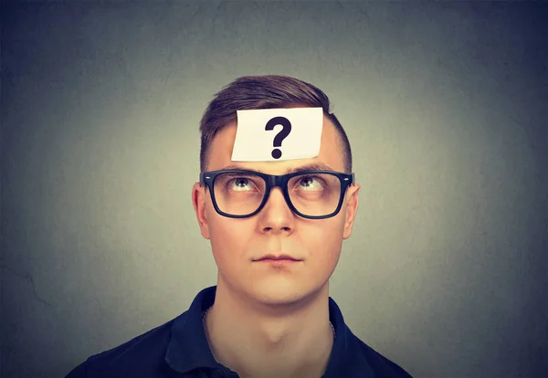 Thinking man with question mark on gray wall background Stock Photo by ...