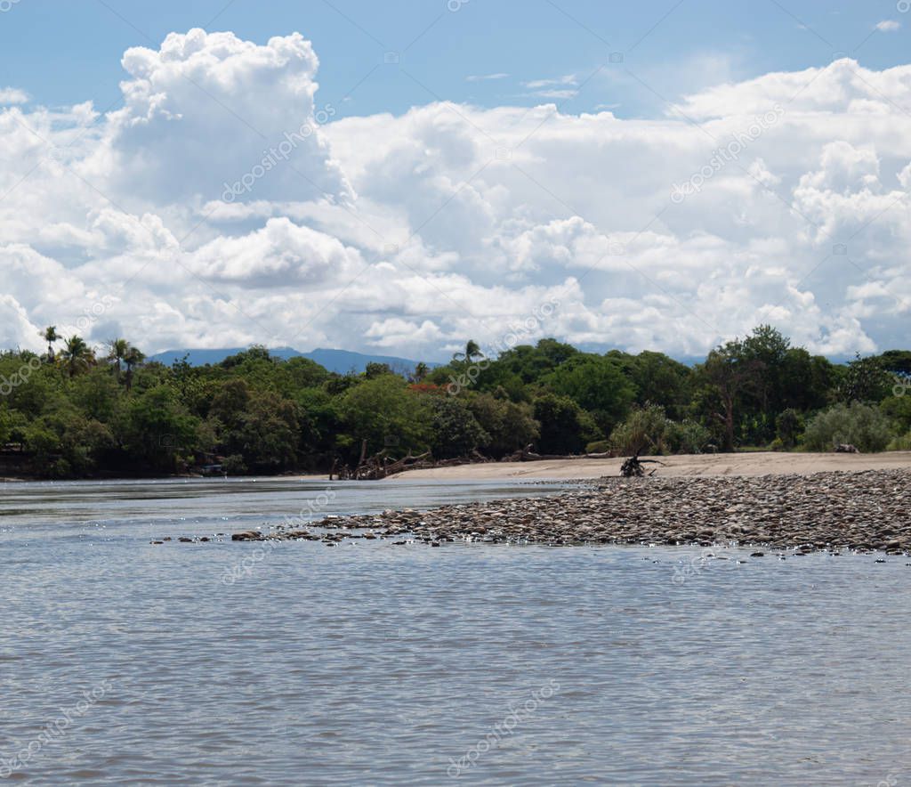 Río Magdalena en día soleado con piedras, bancos de arena, árboles y ...