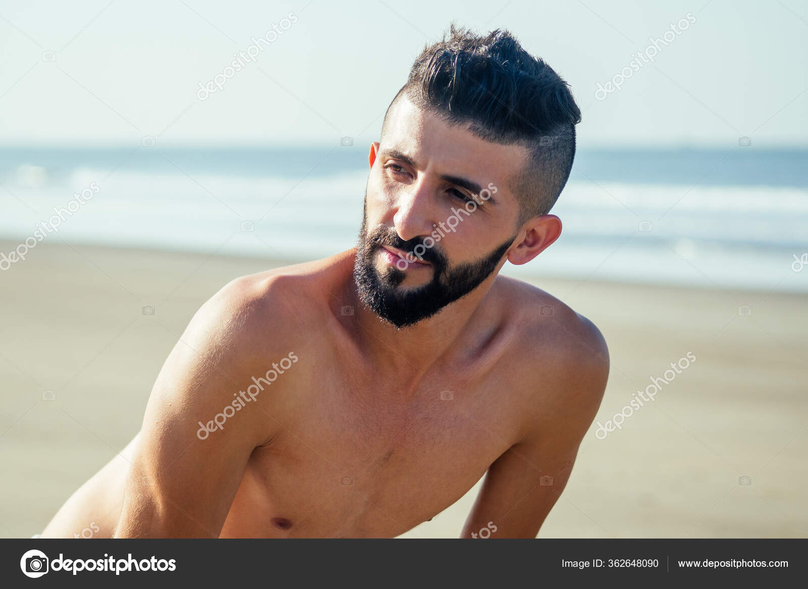 Joven guapo indio descansando después de hacer flexiones en la playa ...