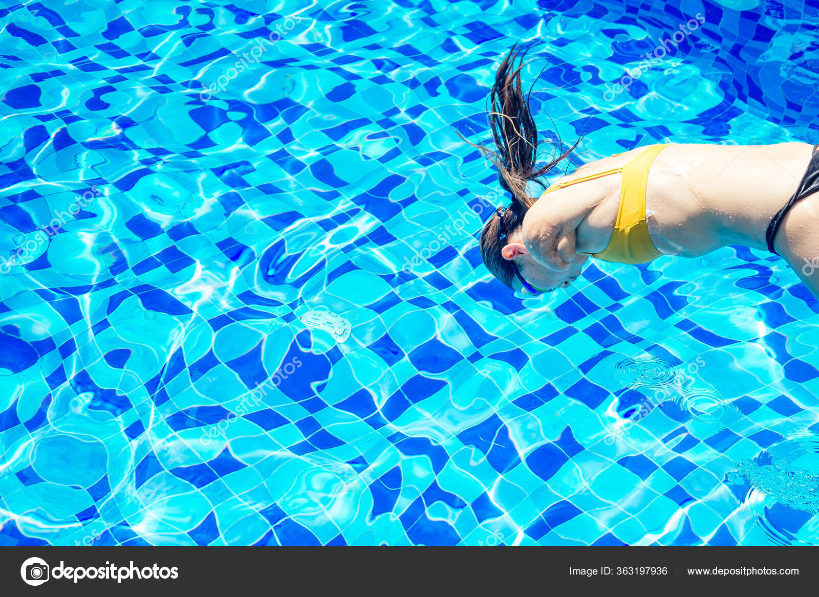 Beautiful young armless woman training to swim in pool at tropical ...