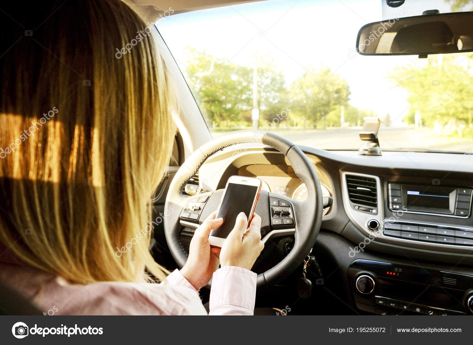 Car interior with female driver sitting behind the wheel, soft sunset ...