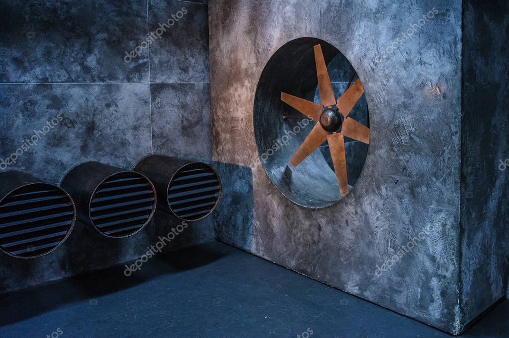 Interior industrial de una antigua fábrica con tuberías, rejillas de ventilación y una gran ...