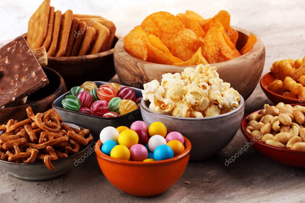 Snacks salados. Pretzels, papas fritas, galletas en cuencos de madera. 2023