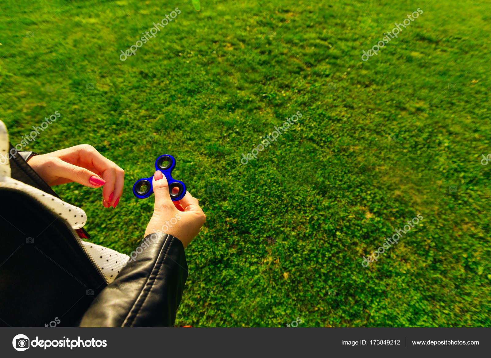 Hand Holds Fidget Finger Spinner Anxiety Relief Toy Green Grass Stock ...