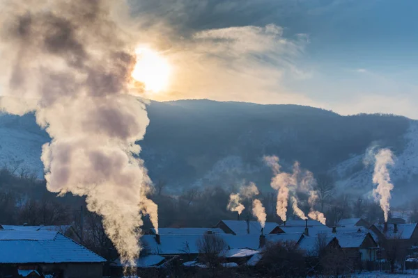 Beautiful winter scenery with smoke coming from house chimneys, on a ...
