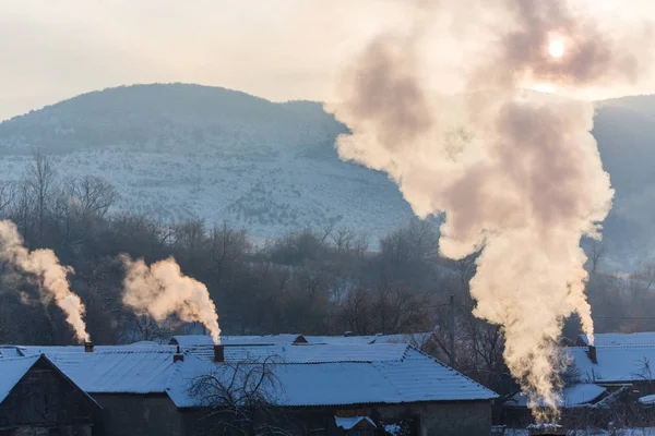 Beautiful winter scenery with smoke coming from house chimneys, on a ...