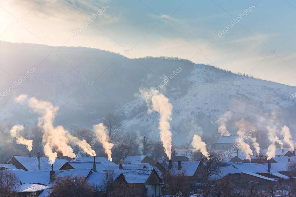 Beautiful winter scenery with smoke coming from house chimneys, on a ...