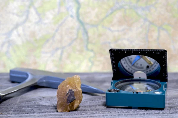 A geologists hammer, a compass, and a mineral interspersed with iron ...