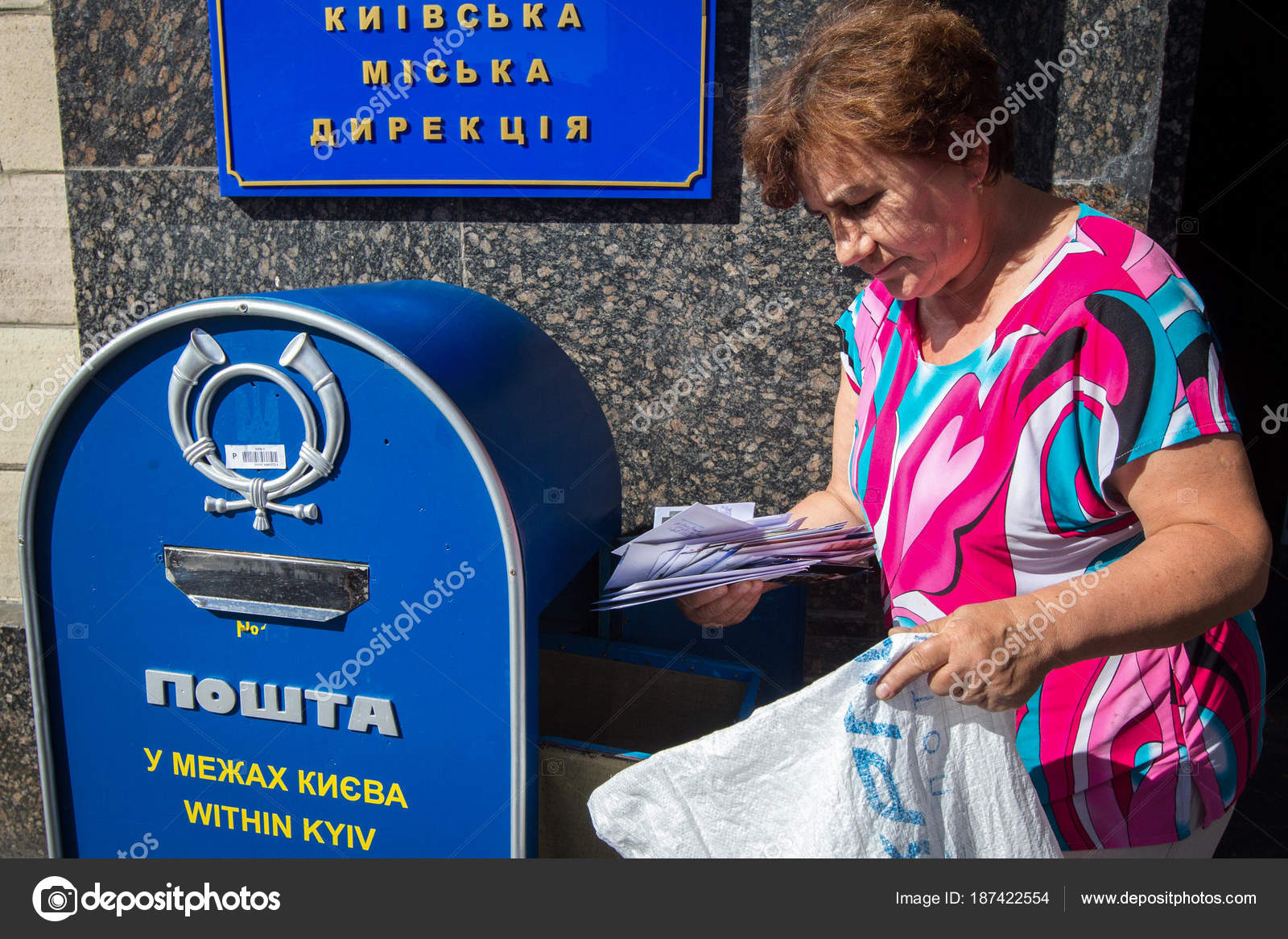 The postman pulls letters from the mailbox near the main post office in ...