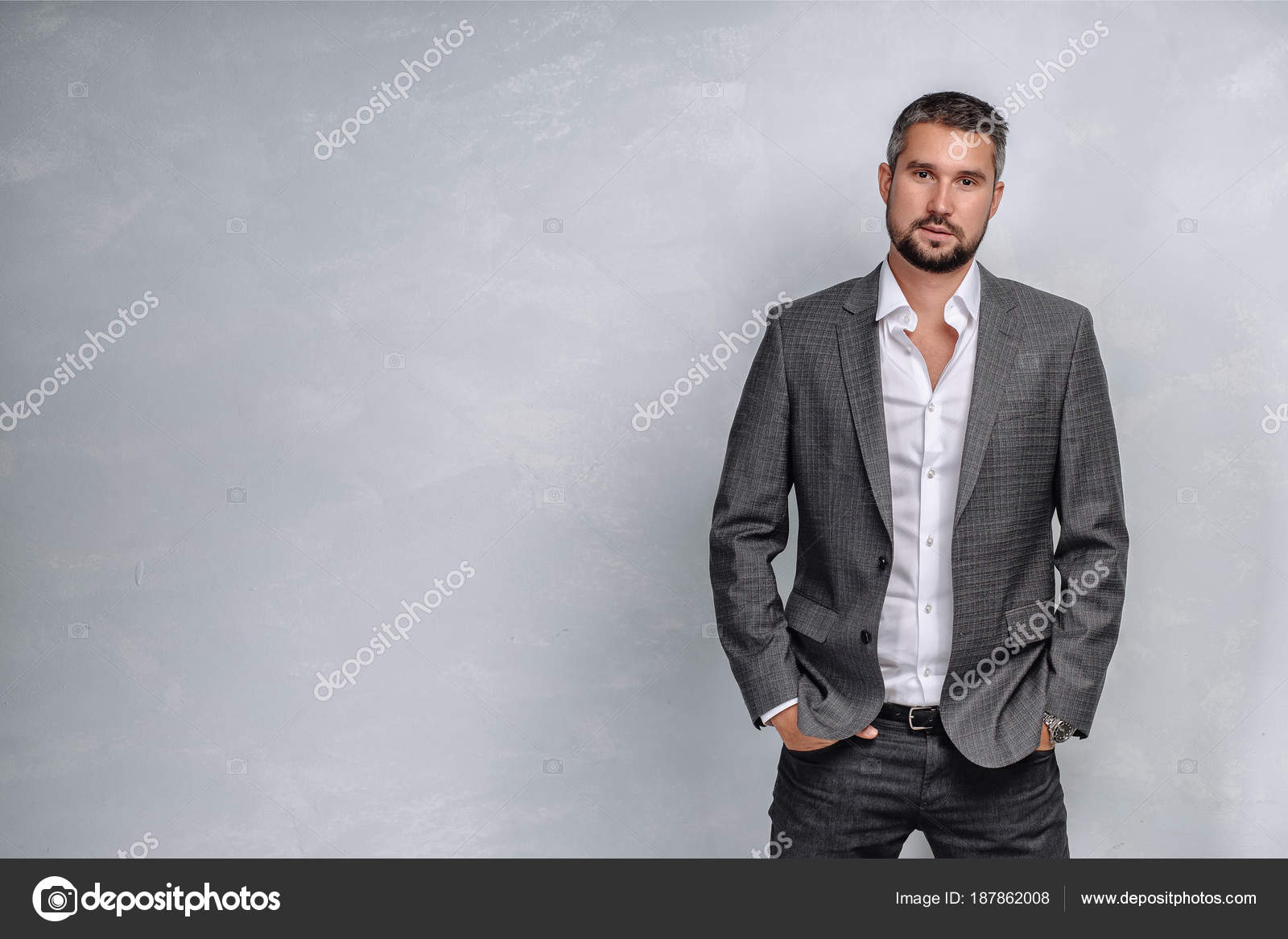 Serious CEO stands on the background of a clean wall. Businessman in a ...