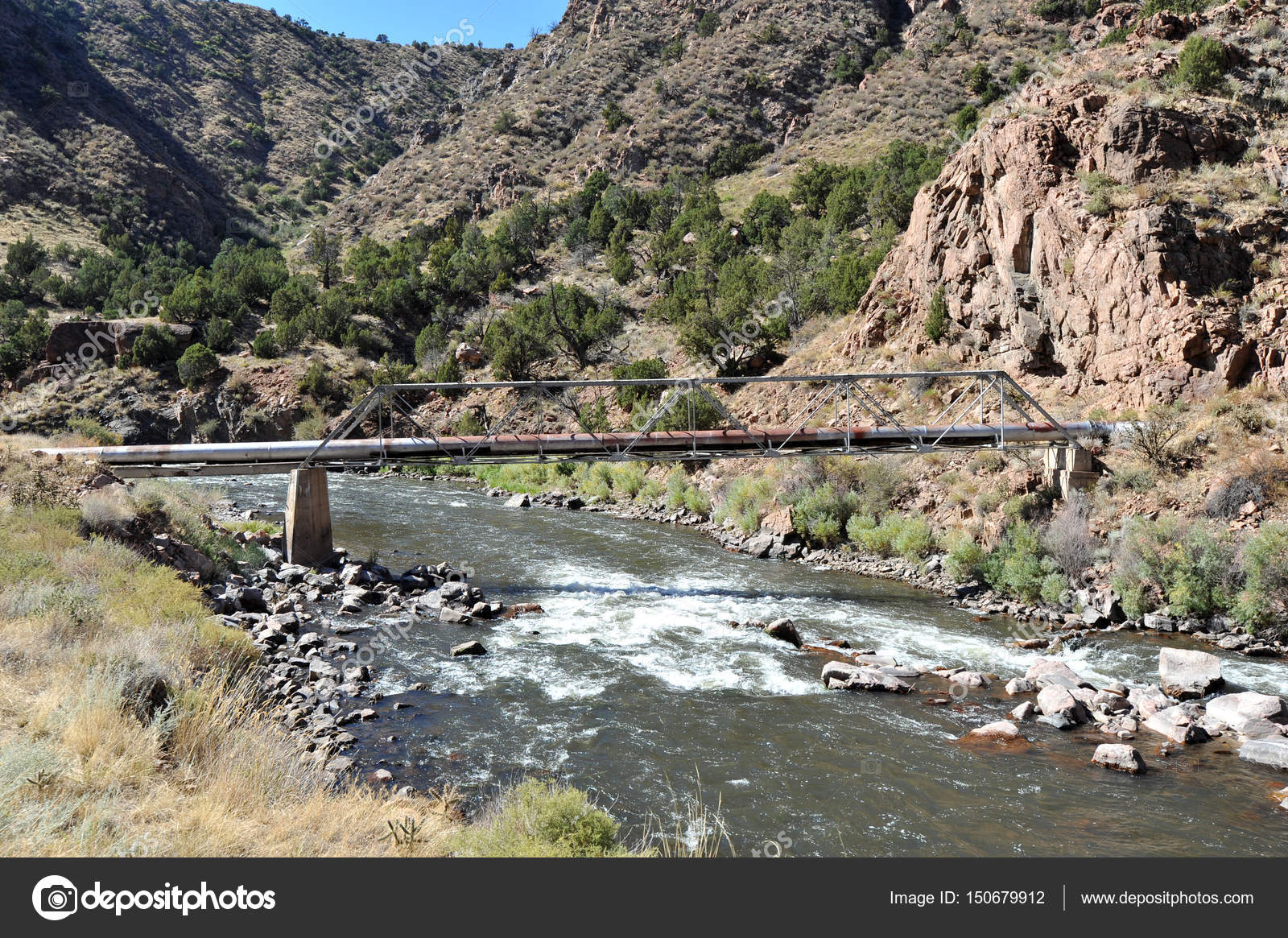 Pipeline stretching across a river between two mountains — Stock Photo ...
