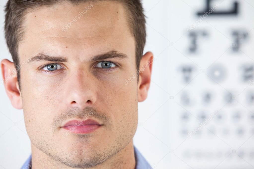 Man wearing contact lens with eye chart — Stock Photo © Wavebreakmedia ...