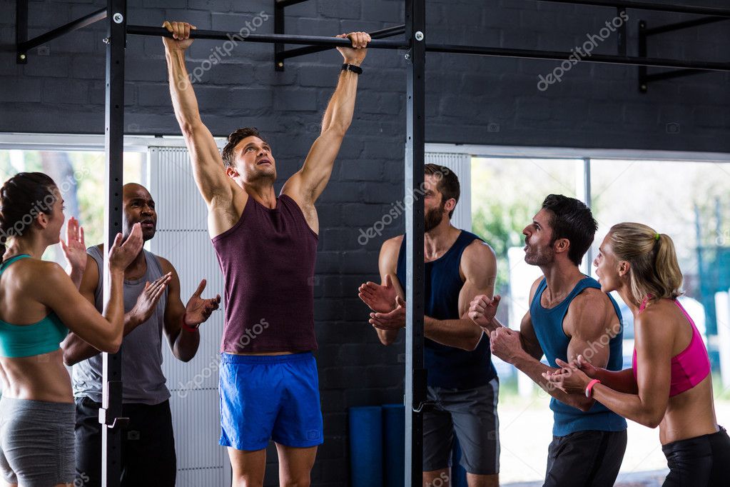 Friends cheering man doing chin-ups Stock Photo by ©Wavebreakmedia ...