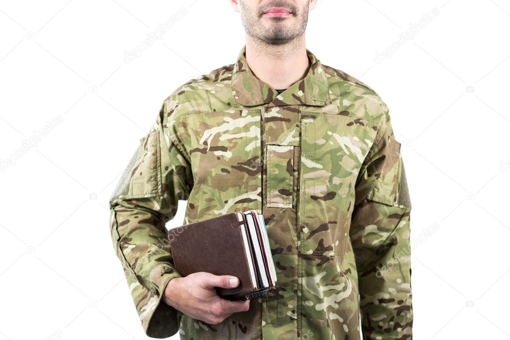 Soldier holding books Stock Photo by ©Wavebreakmedia 126943642