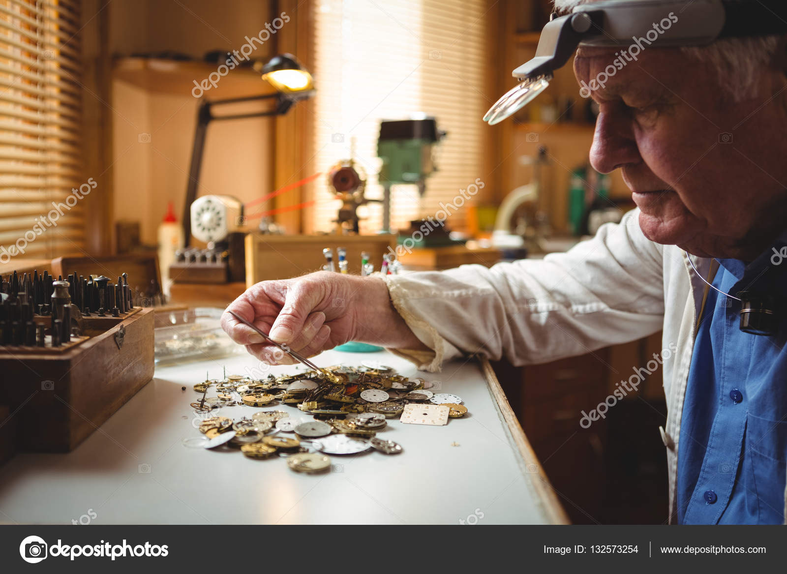 Horologist selecting a clock dial with tweezers Stock Photo by ...