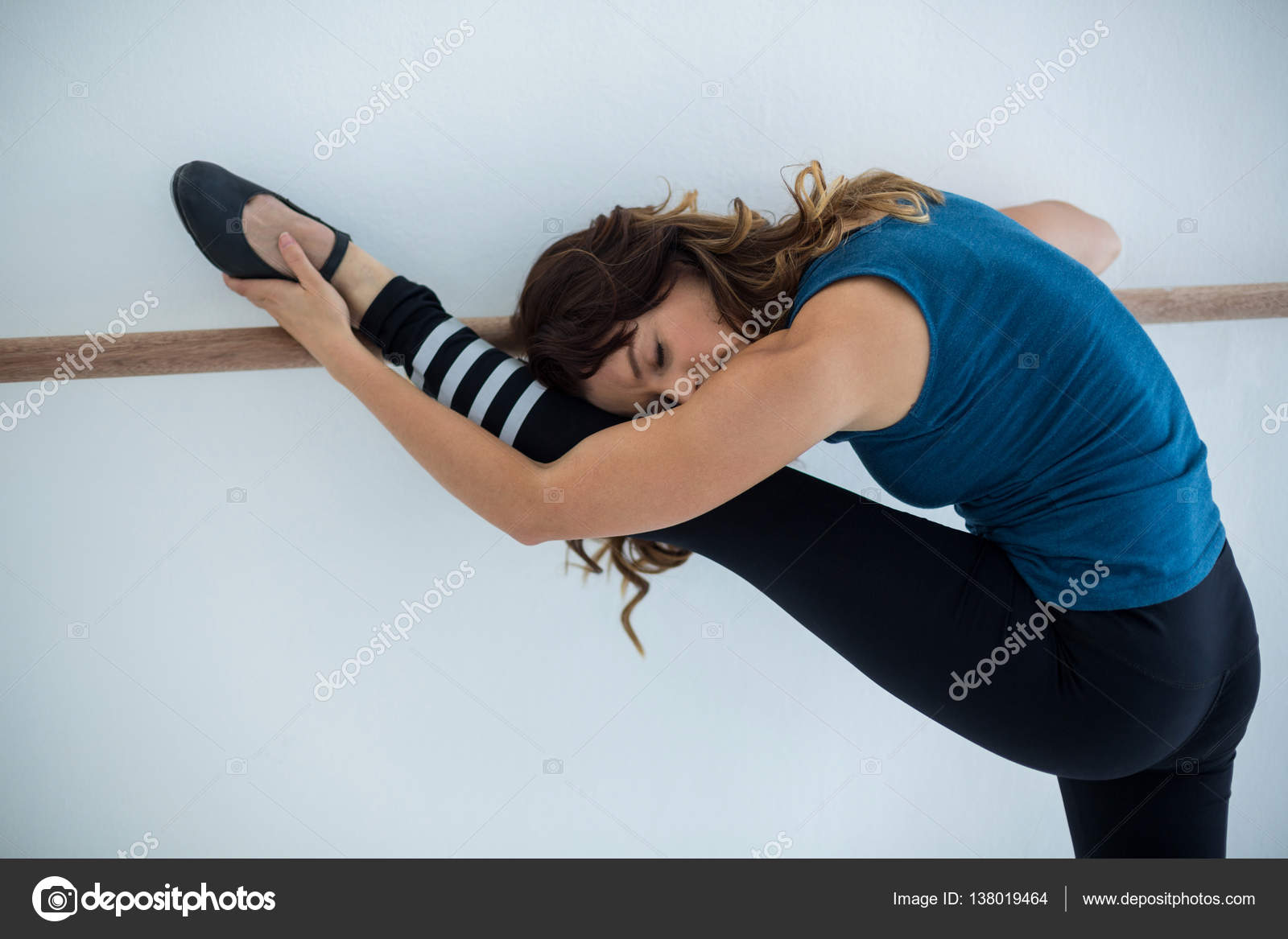 Dancer stretching on a barre while practicing dance Stock Photo by ...