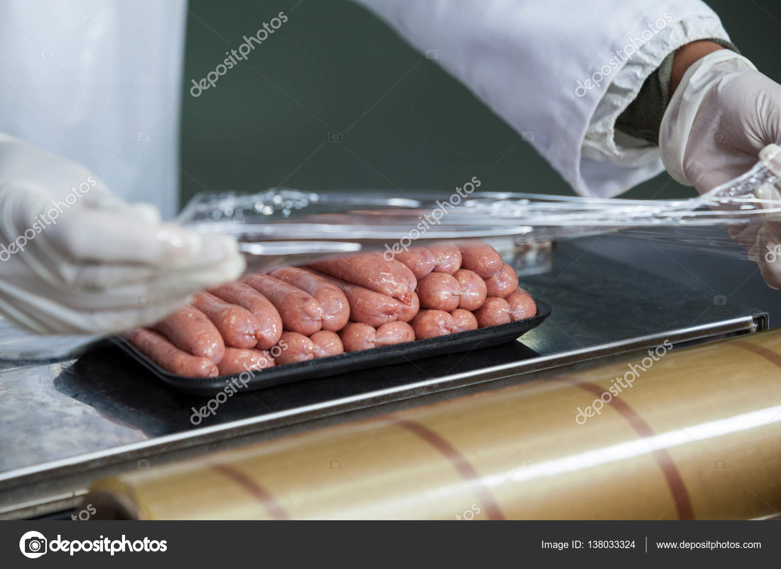 Butcher packing raw sausages Stock Photo by ©Wavebreakmedia 138033324