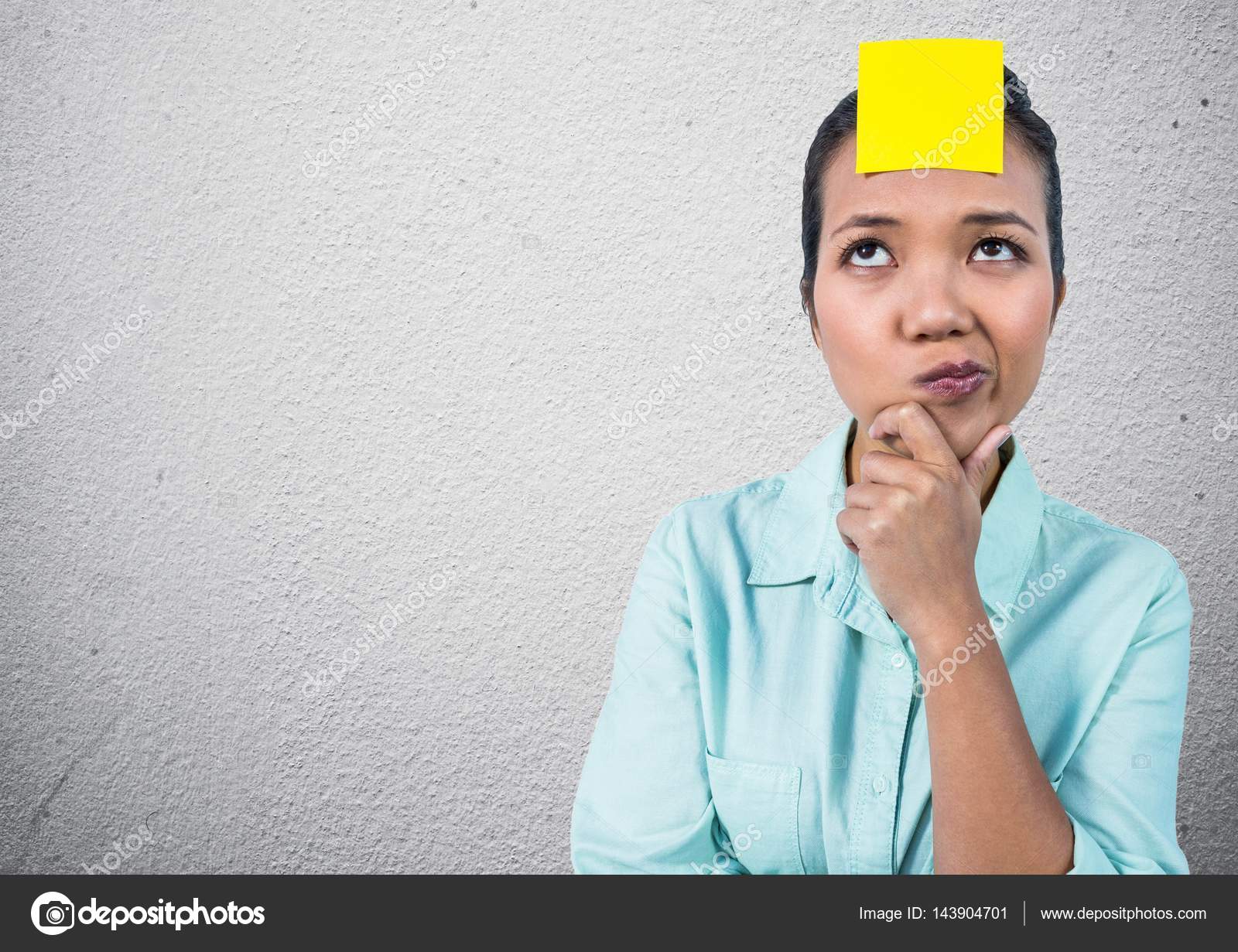 Thoughtful woman with sticky note on her forehead Stock Photo by ...