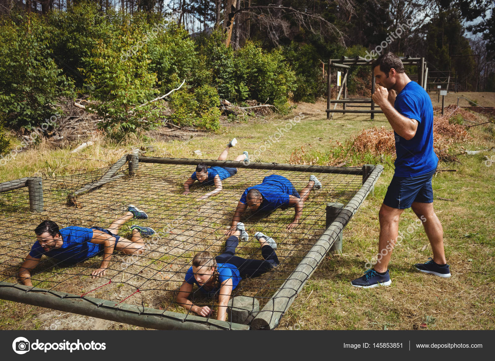 Fit people crawling under the net during obstacle course — Stock Photo ...
