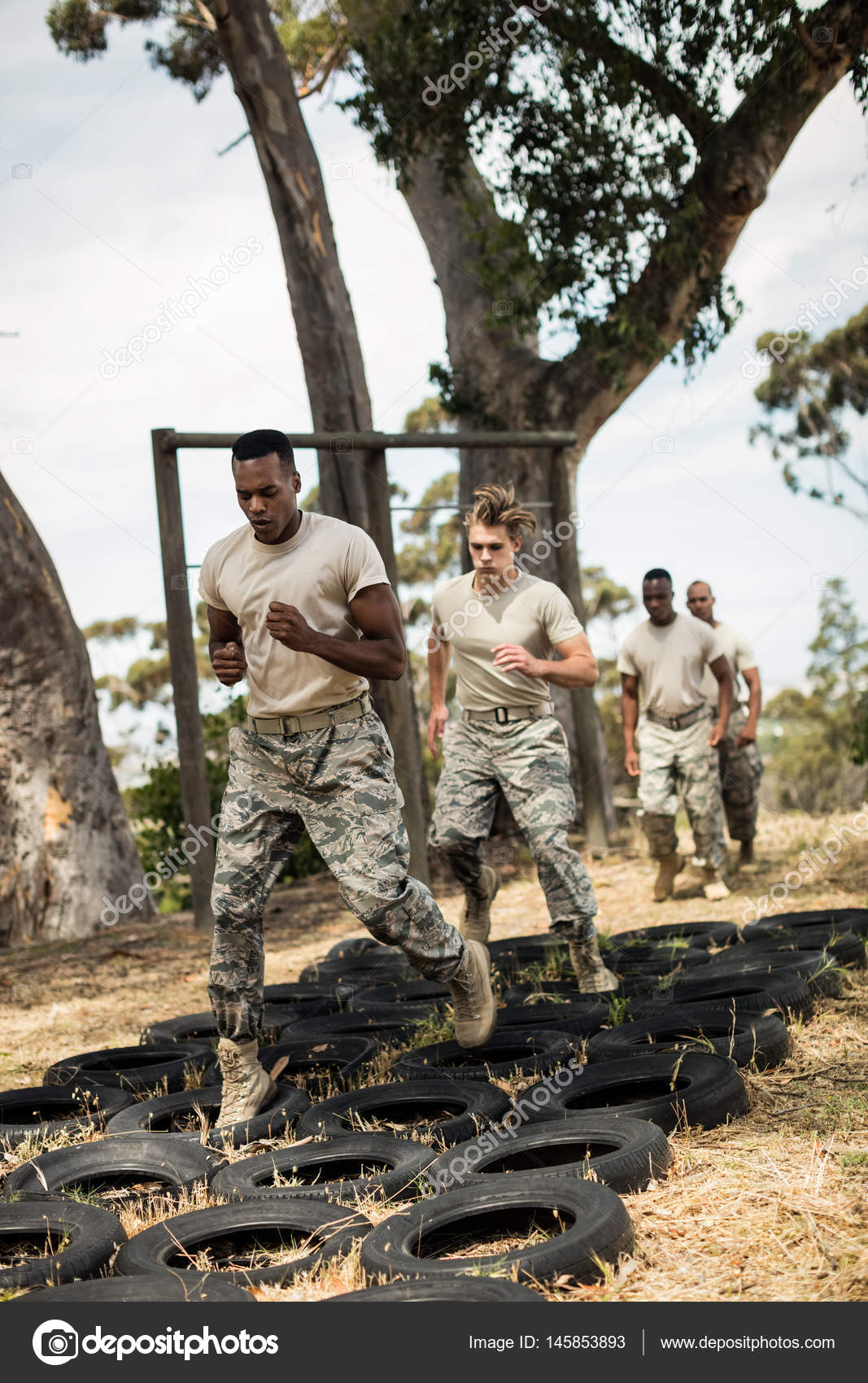 Young military soldiers practicing tyre obstacle course — Stock Photo ...
