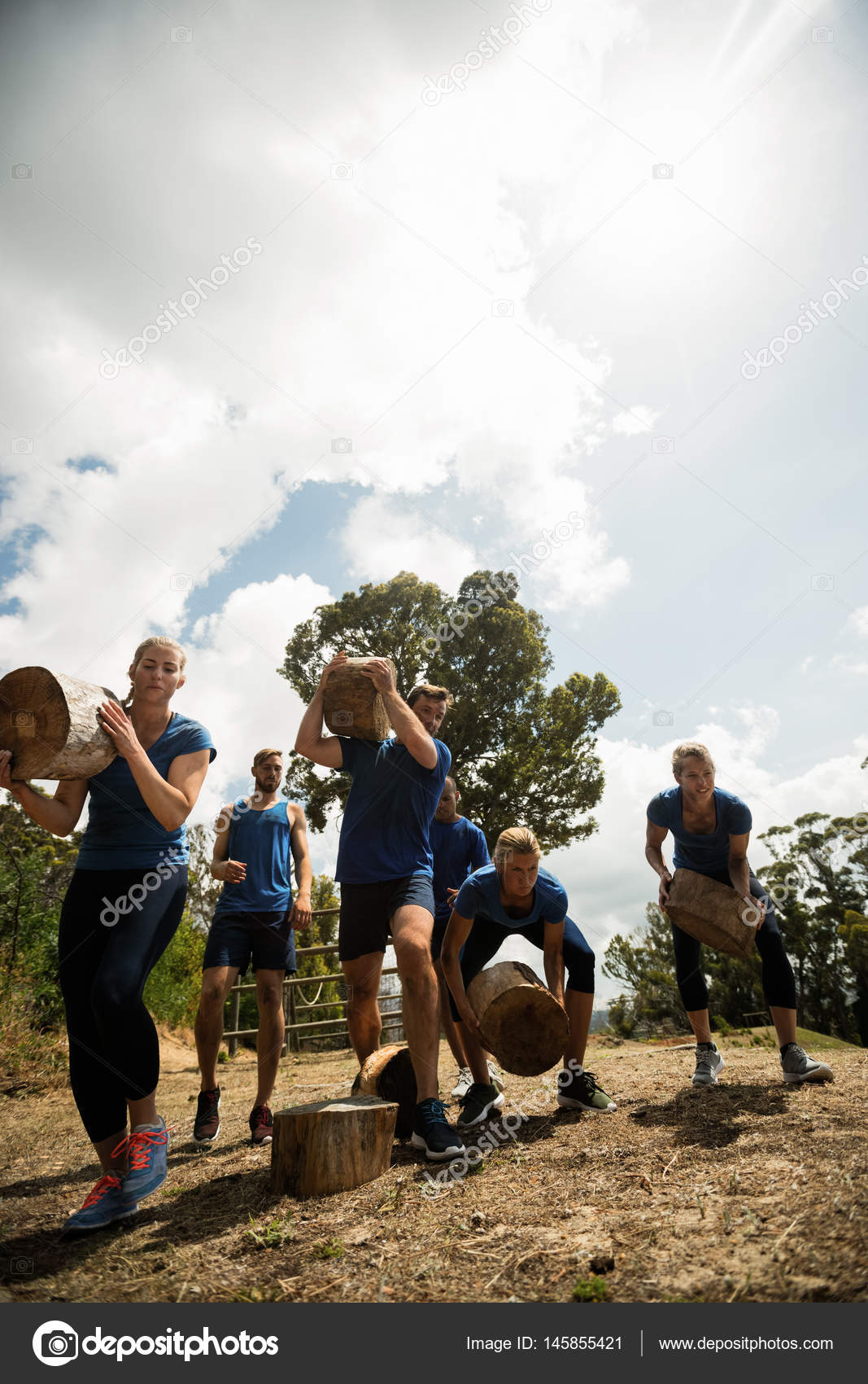 People lifting heavy wooden logs during obstacle course Stock Photo by ...