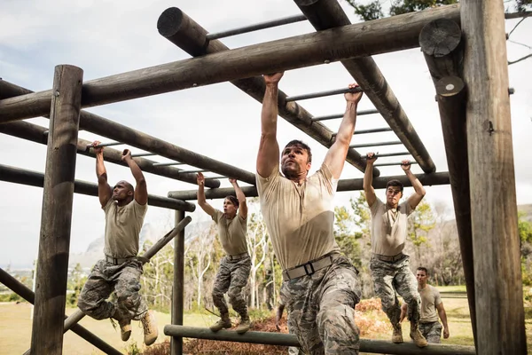 Soldiers helping man to climb wooden wall Stock Photo by ...