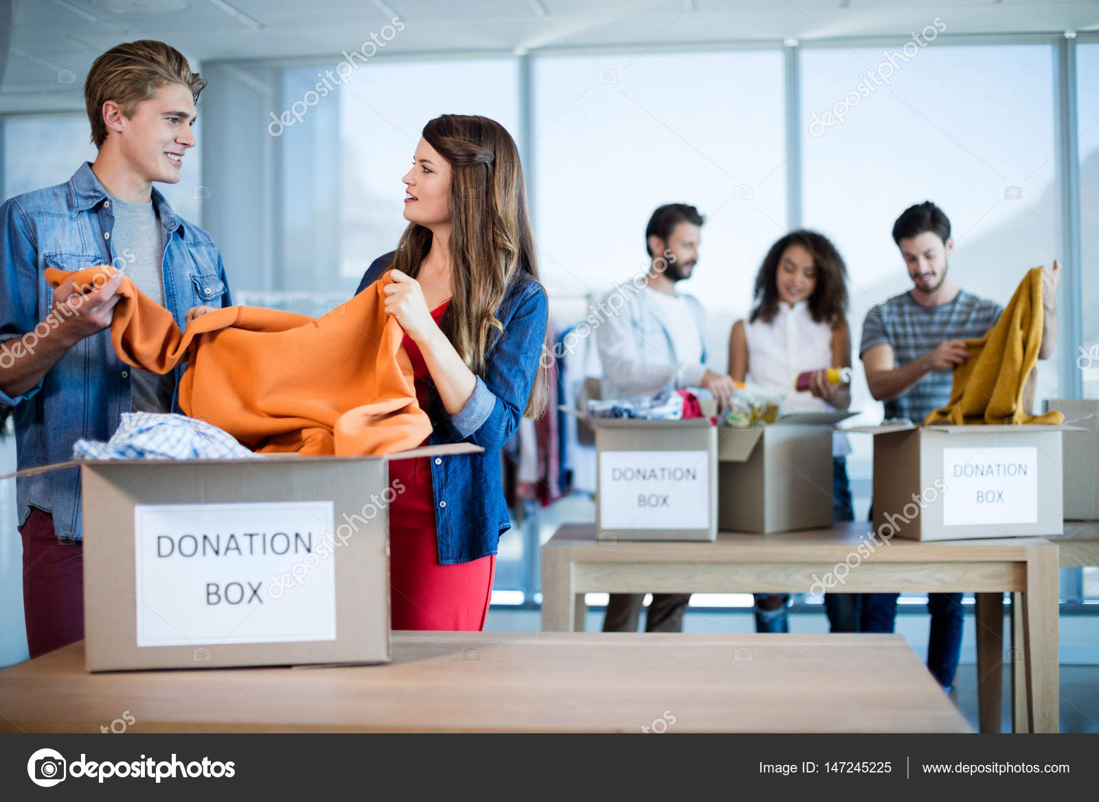 Creative business team sorting clothes in donation box Stock Photo by ...