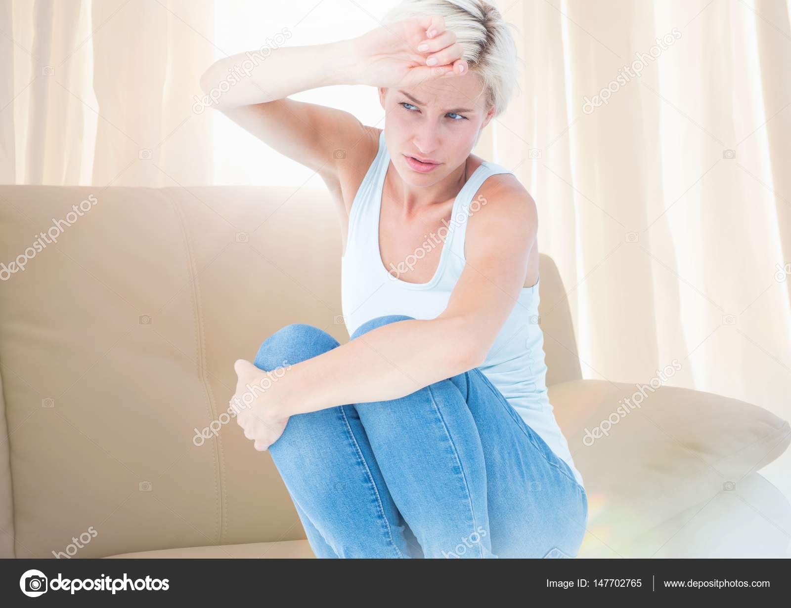 Sad distressed afraid woman crouched near window light Stock Photo by ...