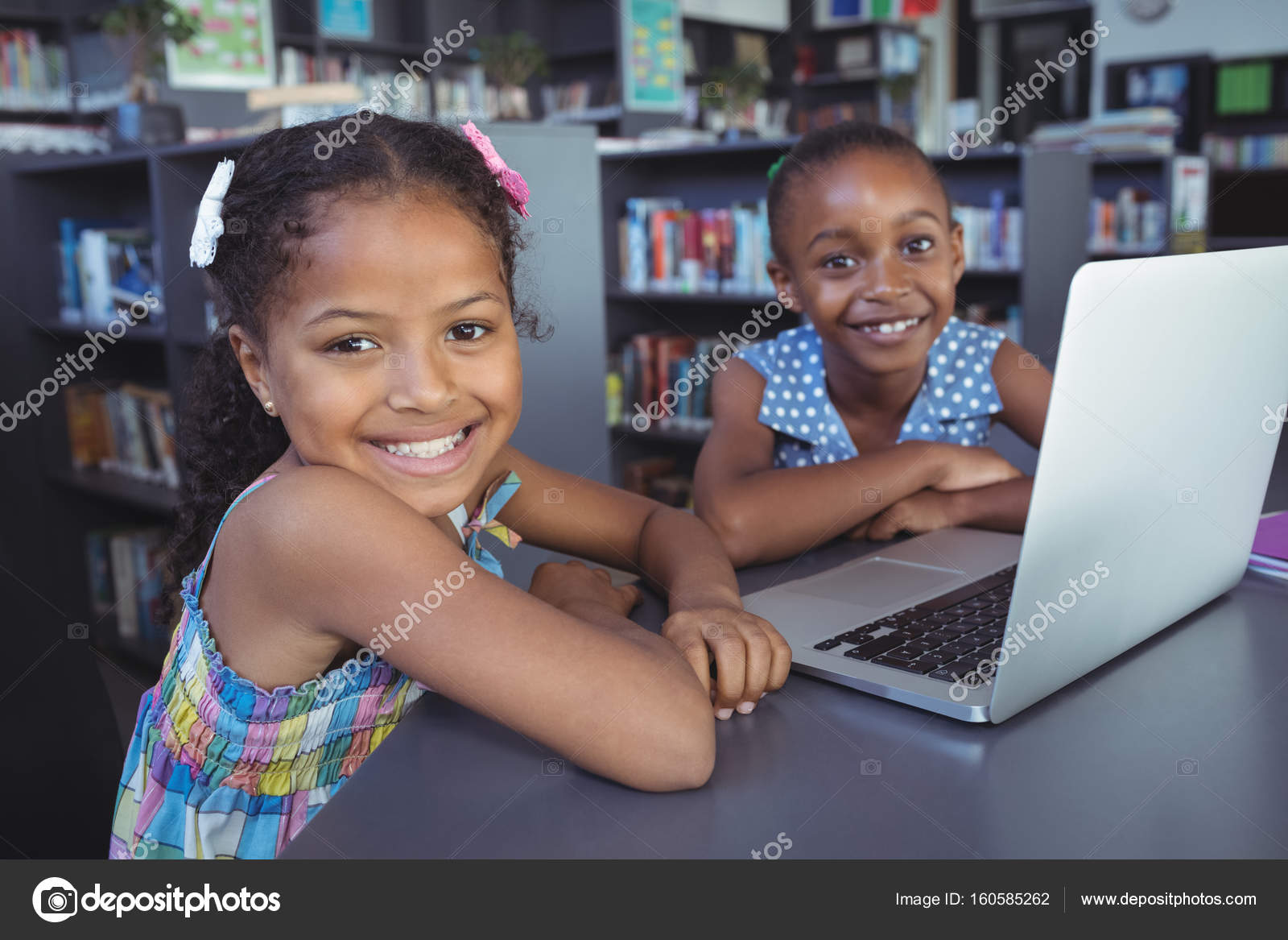 Girls with laptop at desk in library Stock Photo by ©Wavebreakmedia ...