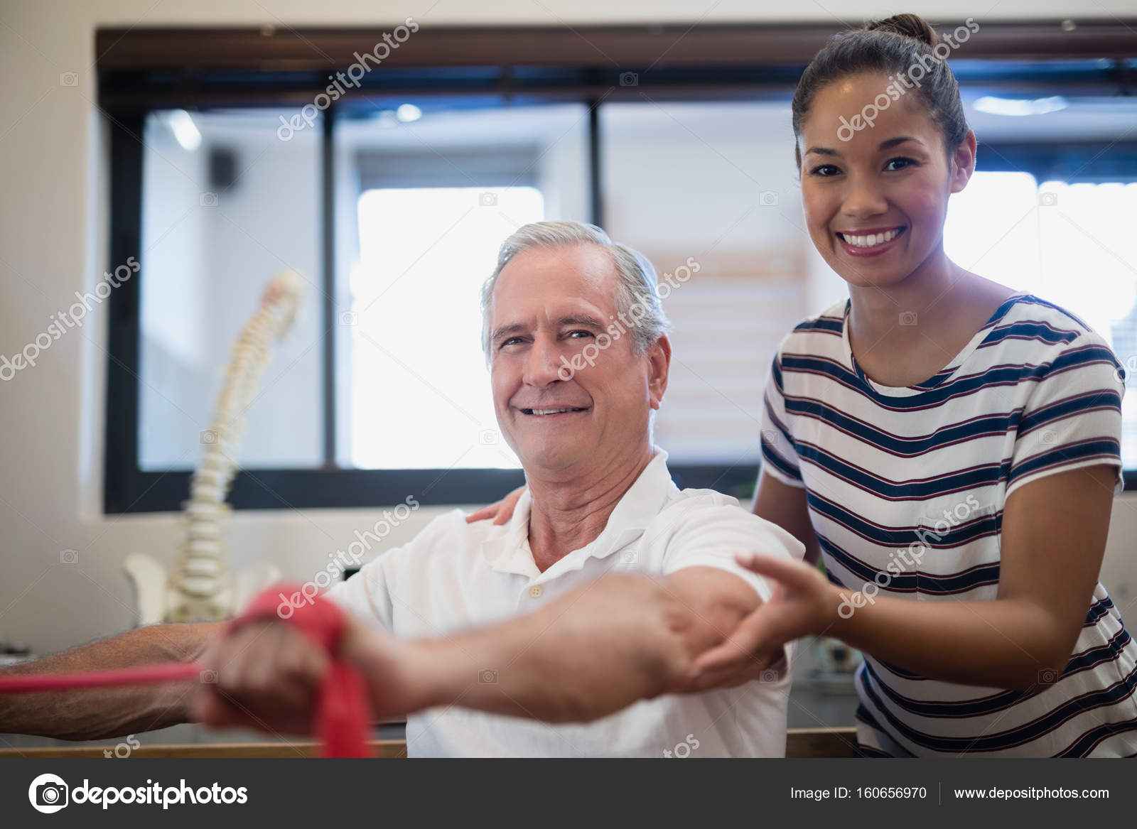 Patient pulling resistance band with doctor Stock Photo by ...