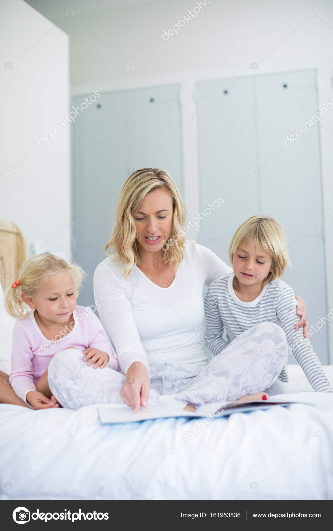Kids and mother reading story book Stock Photo by ©Wavebreakmedia 161953836